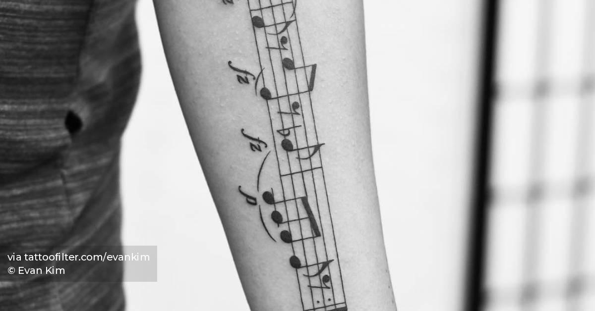 Music staff tattoo located on the inner forearm.