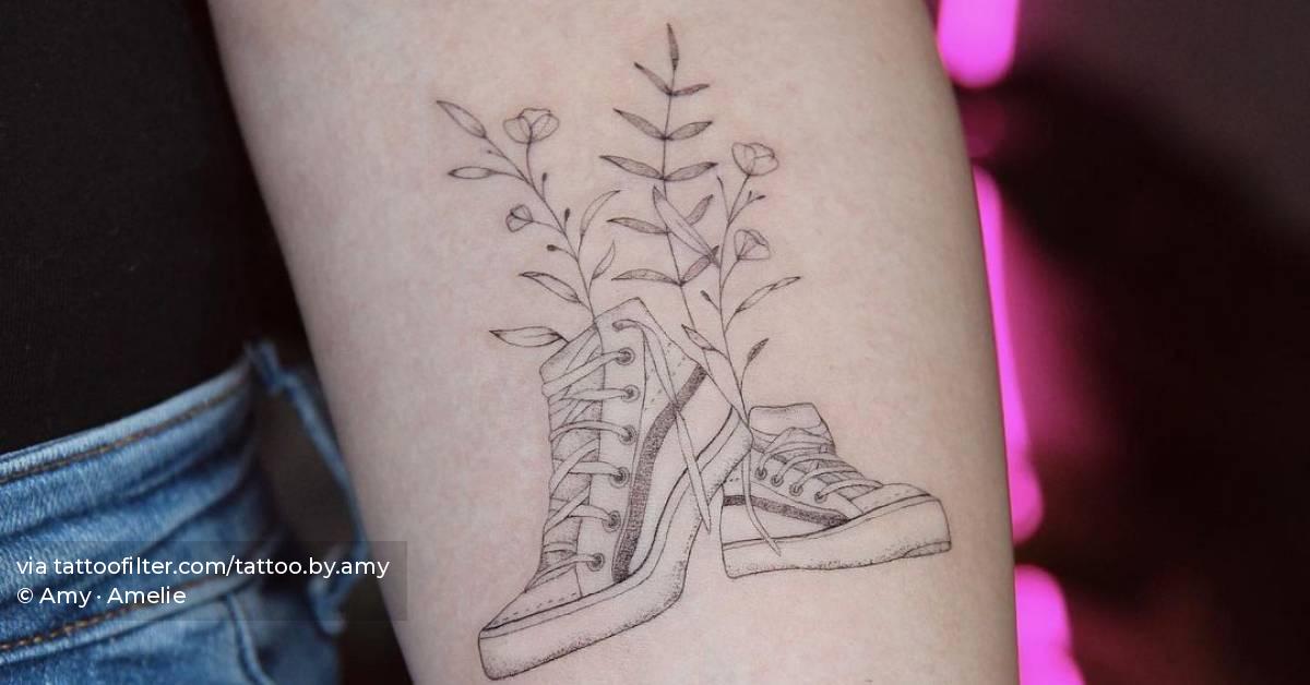 Vans and flowers tattooed on the inner forearm.