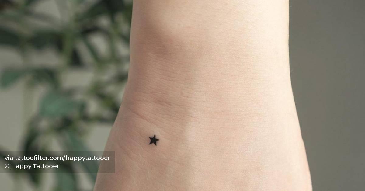 Tiny star tattooed on the wrist, minimalistic style.