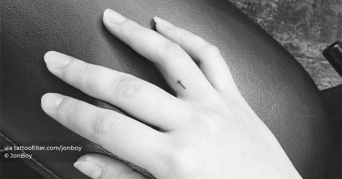 Minimalistic tiny cross tattoo done on the finger.