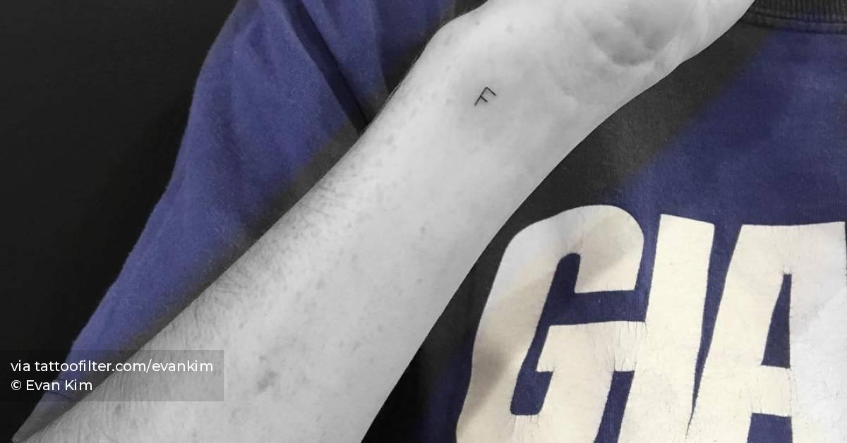 Minimalistic tattoo of the letter "F" located on the