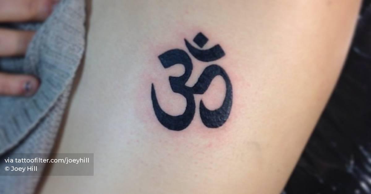 Om symbol tattooed on the upper arm.