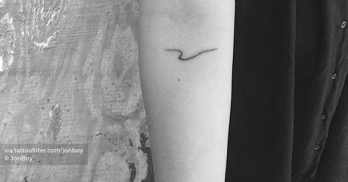 Tiny wave tattoo located on the inner forearm.