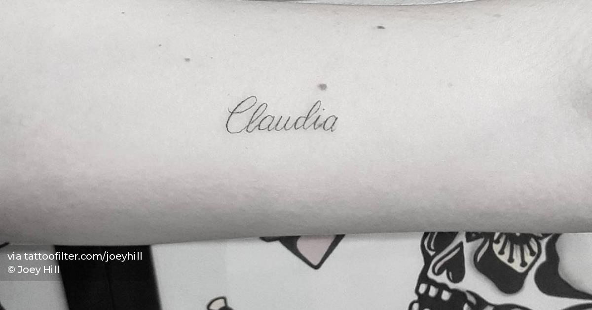 Tattoo of the name "Claudia" located on the bicep.