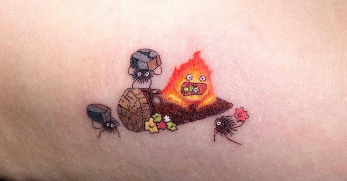 Calcifer and soot sprites tattooed on the inner arm.