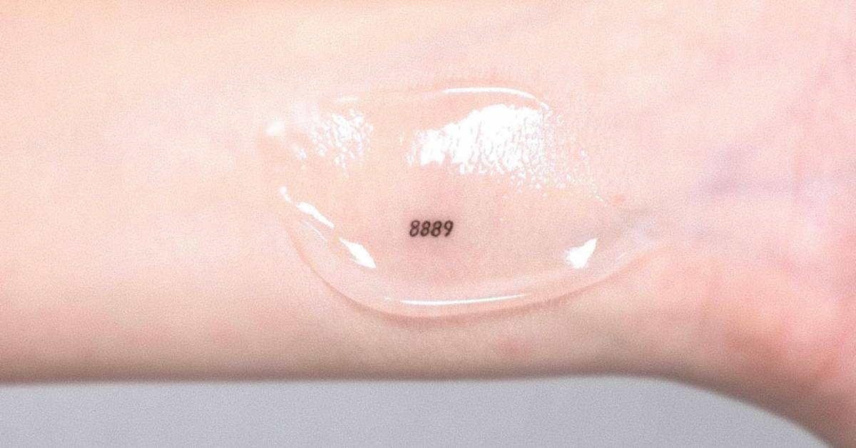 Micro "8889" lettering tattoo located on the wrist.