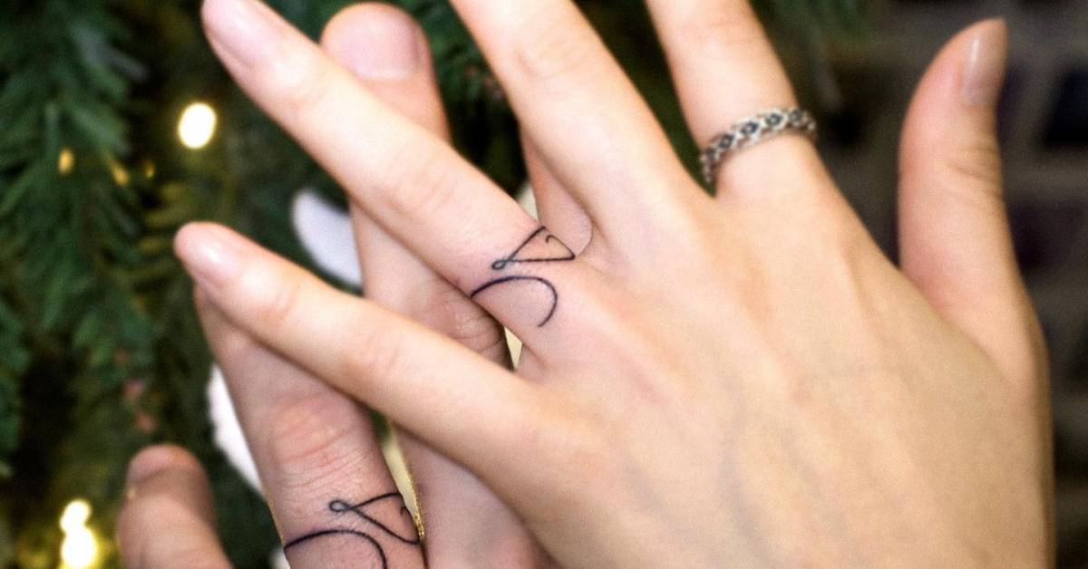 Matching initial ring tattooed for couple.