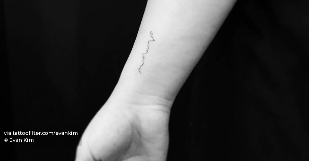 Fine line style heartbeat tattoo placed on the wrist.
