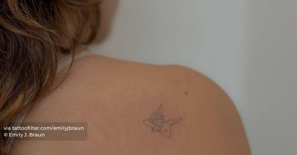 Fine line cherub tattoo located on the shoulder blade.