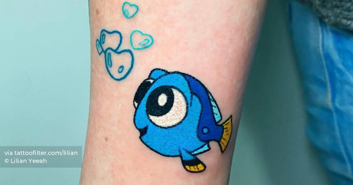 Dory tattoo hand poked on the wrist, cartoon style.