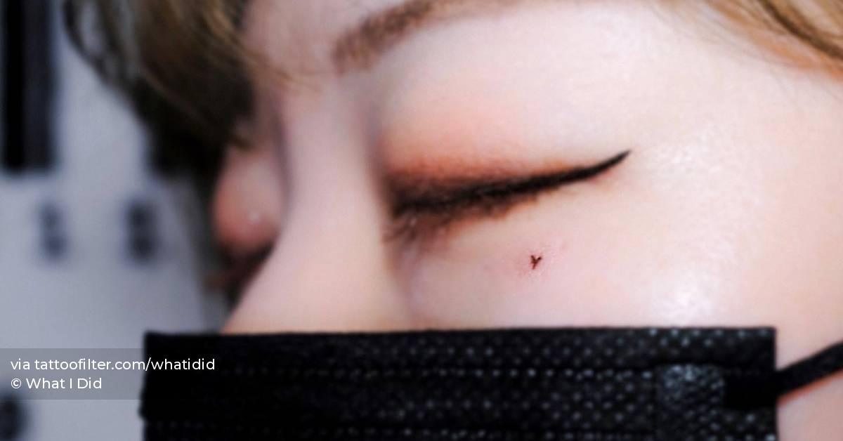 Tiny letter "Y" tattoo located on the face.