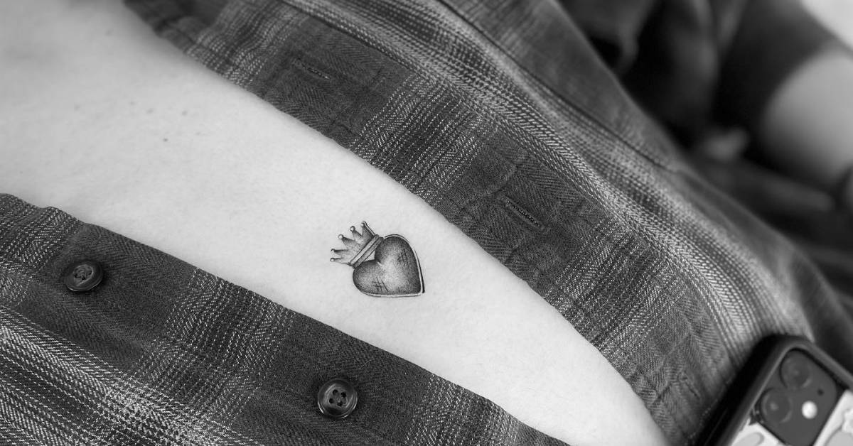 Heart and crown tattoo located on the sternum.