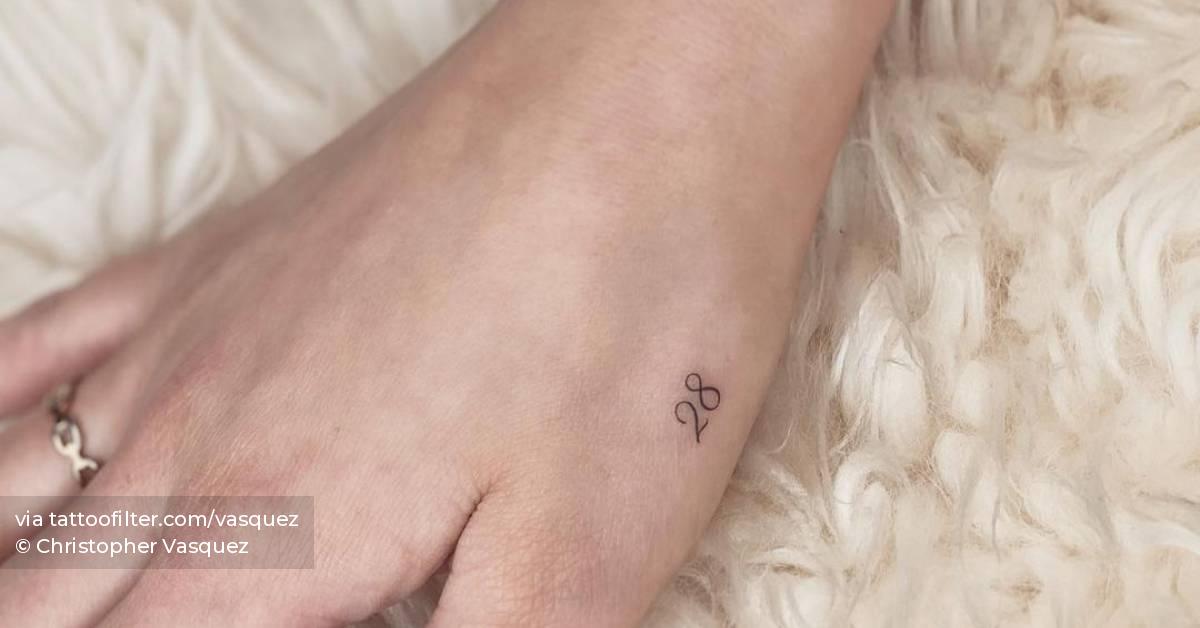 Tiny number "28" tattoo located on the hand.