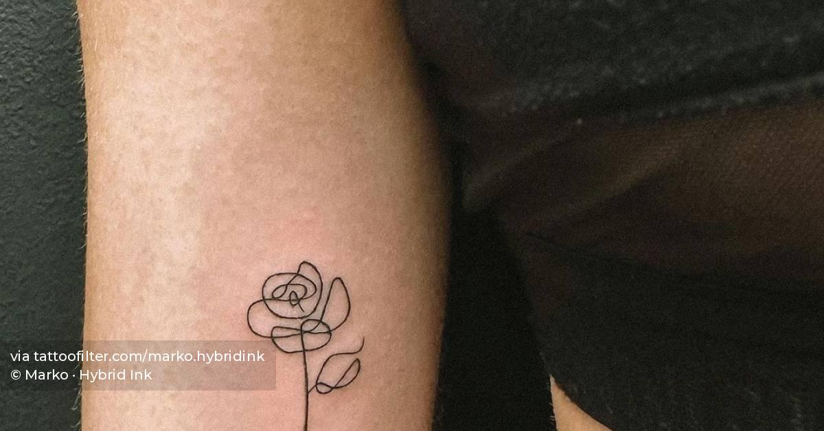One line rose tattooed on the inner arm.