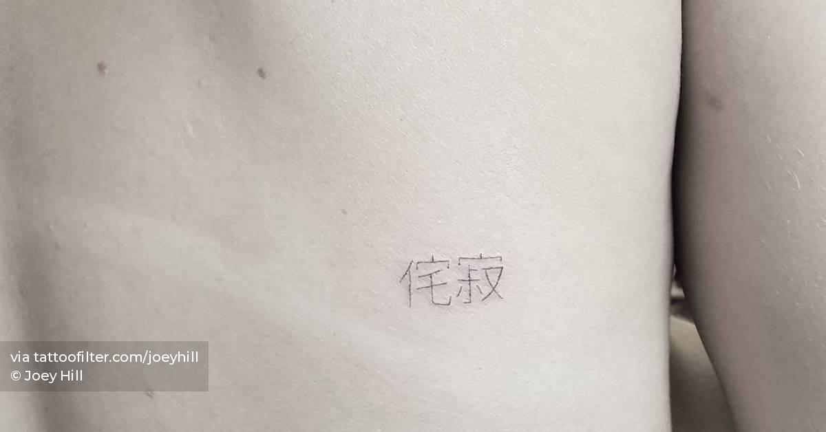 Chinese lettering tattoo located on the back.