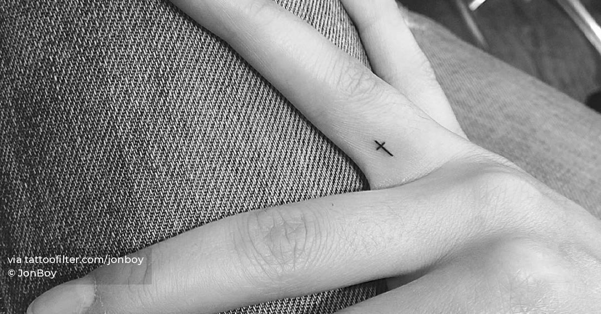 Micro cross tattoo done on the finger, minimalistic