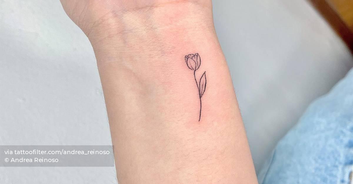 Fine line tulip tattoo located on the wrist.