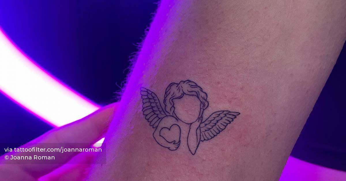 Fine line cherub tattoo located on the upper arm.