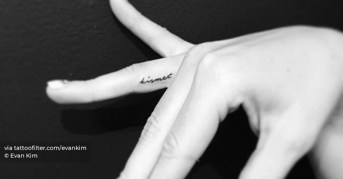 Tattoo of the word "kismet" located on the finger.