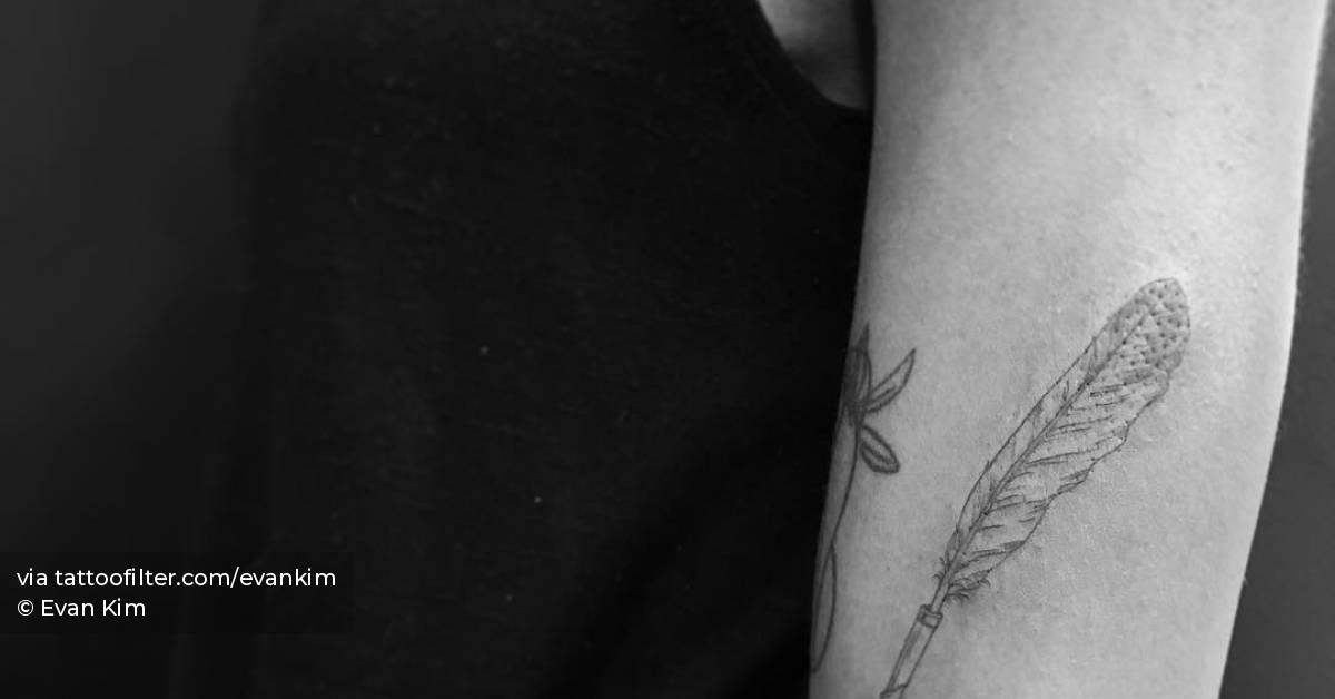 Quill tattoo located on the upper arm, fine line style.