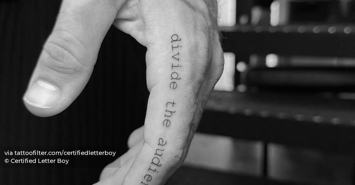 "Divide the audience" lettering tattoo located on the