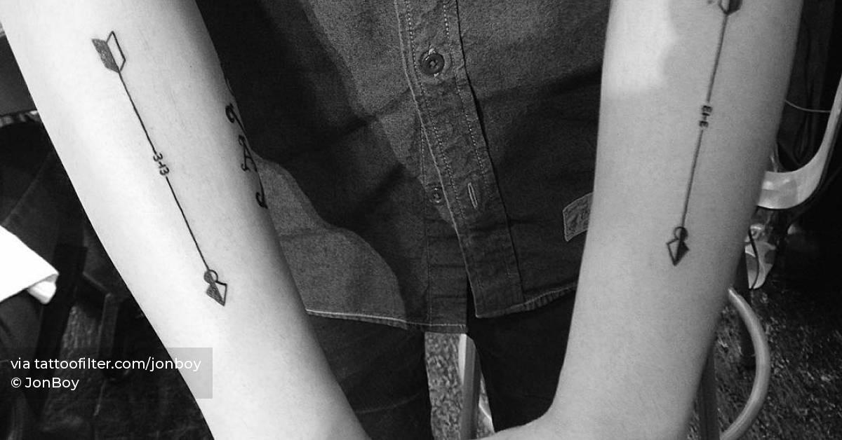 Individual matching arrows tattooed on the forearms.