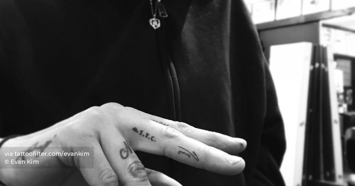 Tiny signature tattoo located on the finger.