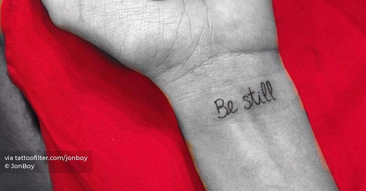 "Be still" lettering tattoo handwritten on the wrist.