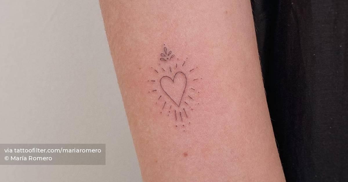 Fine line ornamental heart tattooed on the forearm.