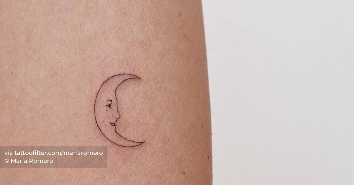 Minimalistic moon face tattoo done on the upper arm.