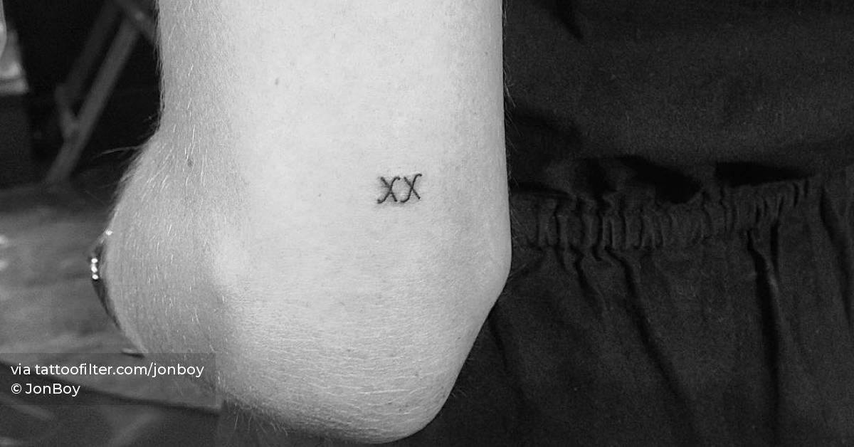 "XX" lettering tattoo done on the tricep.
