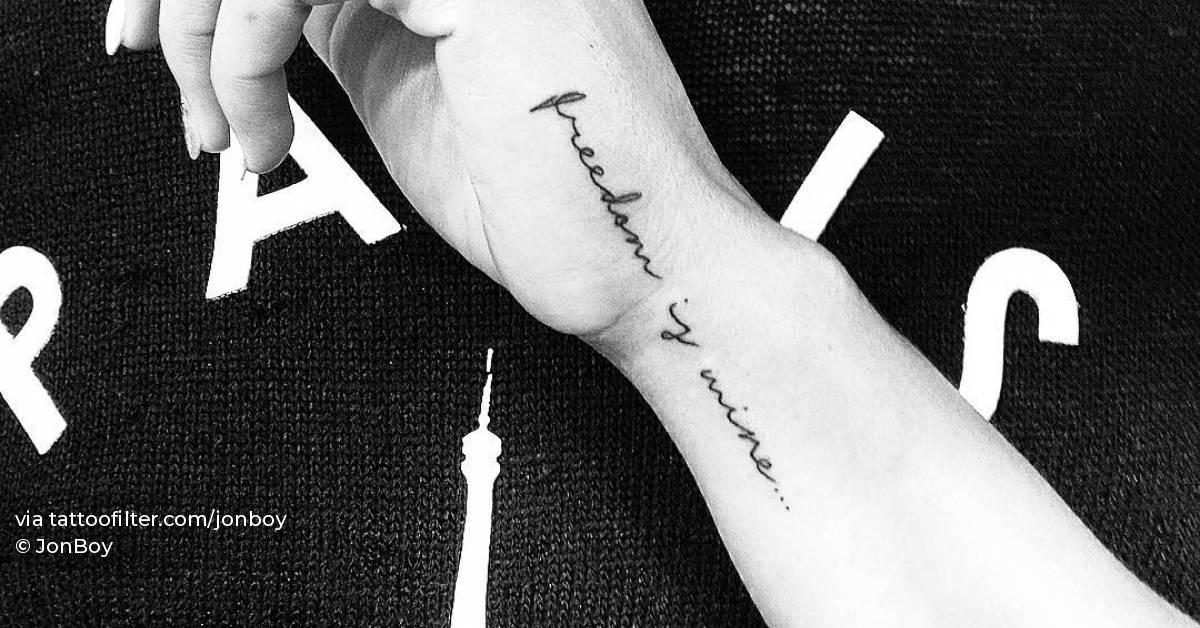 "Freedom is mine" lettering tattoo located on the