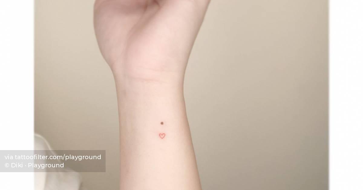 Micro red heart tattoo placed on the wrist.
