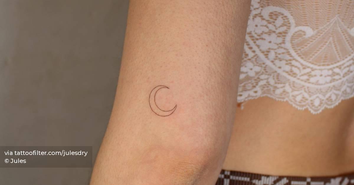 Fine line style crescent moon tattoo located on the