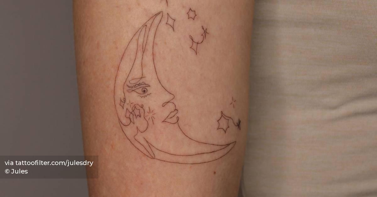 Fine line style moon face tattoo placed on the upper