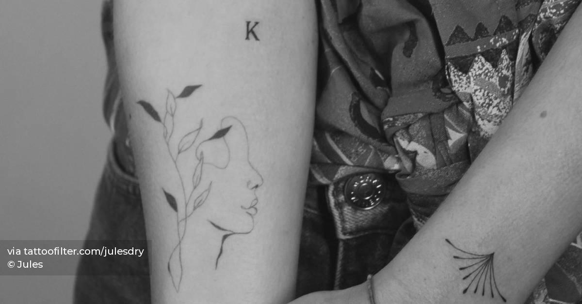 Flower head woman, letter "K" and ornament tattoos.