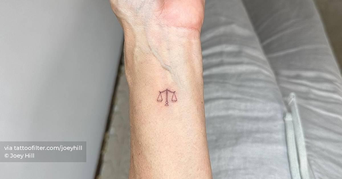 Minimalistic scale tattoo located on the wrist, done