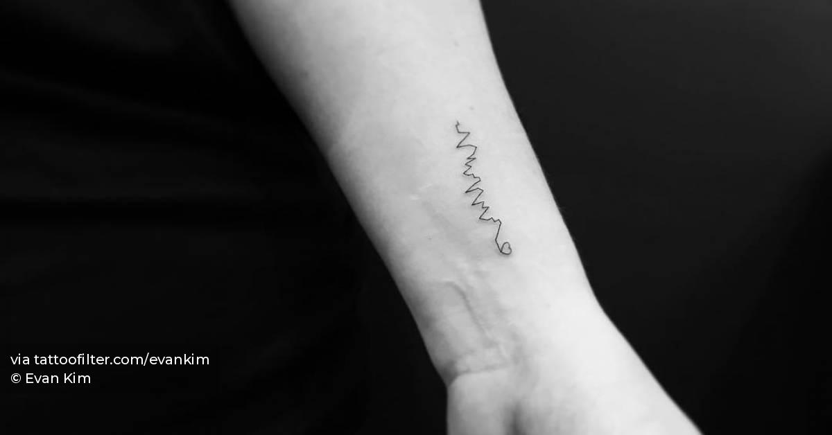 Fine line style heartbeat tattoo located on the wrist.