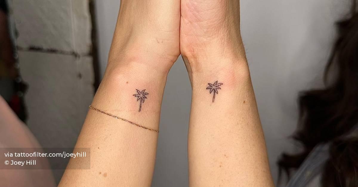 Matching minimalistic palm tree tattoo for couple.
