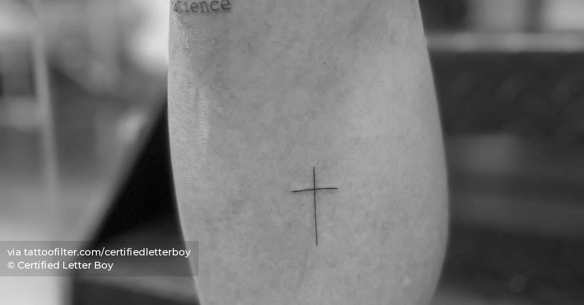 Minimalistic cross tattoo located on Harrison Ashby's