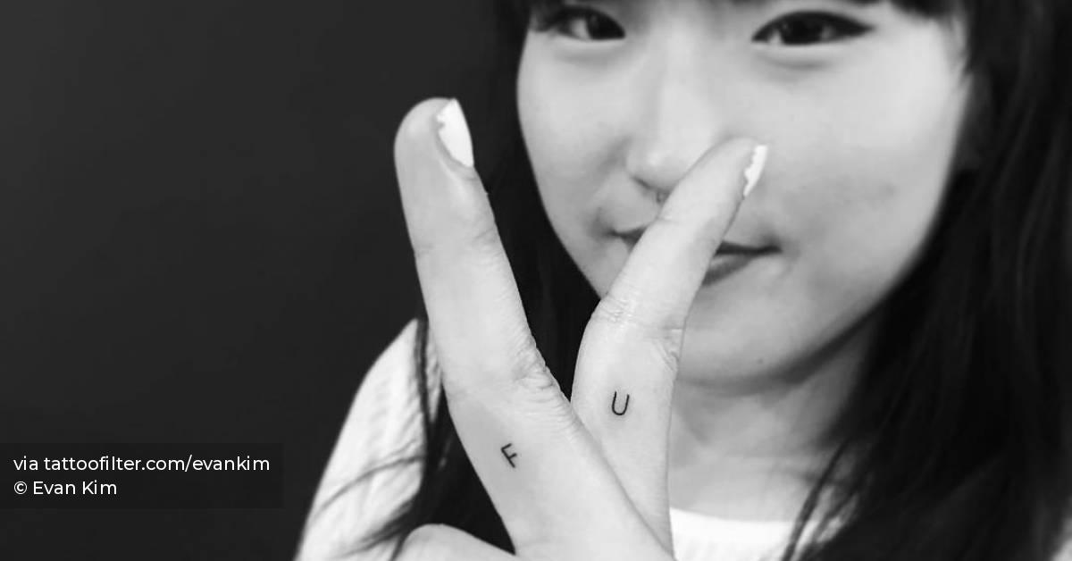 Letters "F" and "U" tattooed on the fingers.