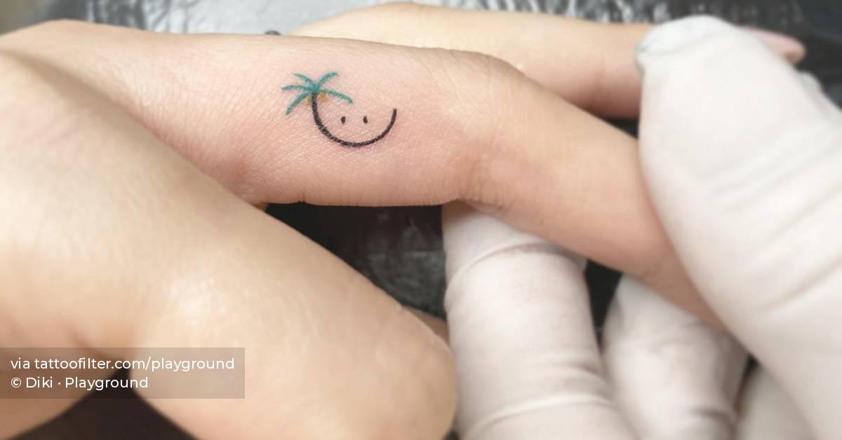 Minimalistic style smiley palm tree tattoo done on the