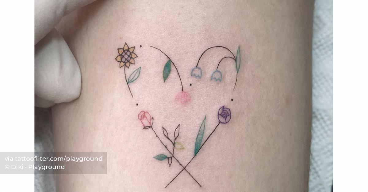 Flower heart tattoo located on the upper arm.