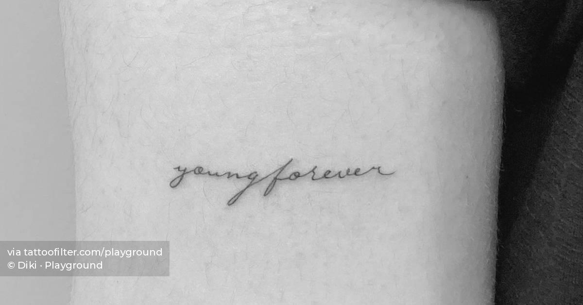 Tattoo that says "young forever" handwritten on the