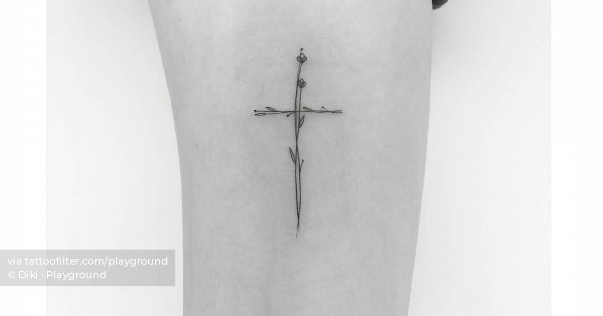 Fine line style flower cross tattoo located on the