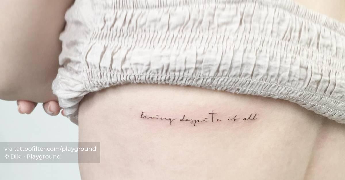 "Living despite it all" lettering tattoo placed on the