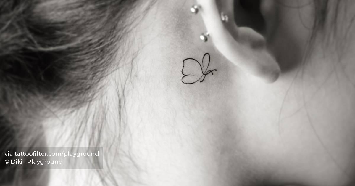 Minimalistic fine line butterfly tattooed behind the