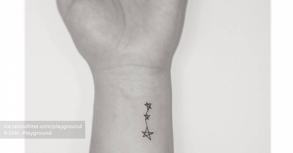 Fine line stars tattooed on the wrist, minimalistic