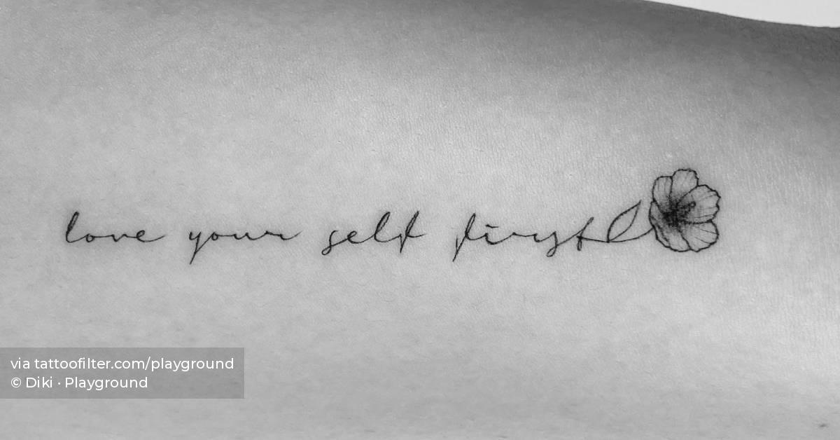 "Love yourself first" and flower tattooed on the inner