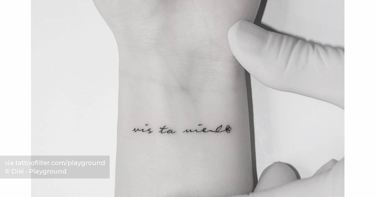 "Vis ta vie" and flower tattooed on the wrist.